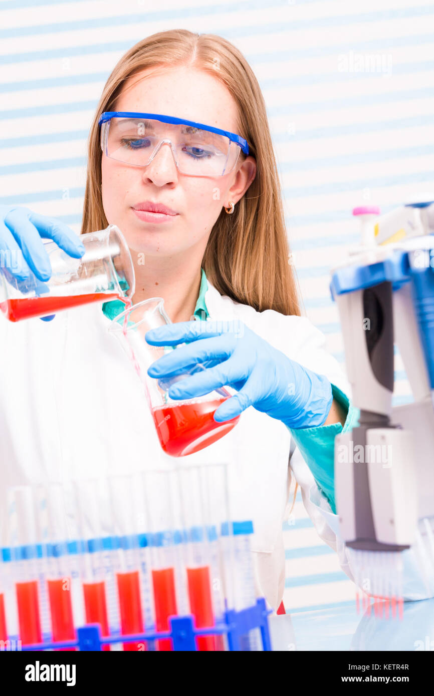 A female lab assistant doing scientific experiments in a scientific ...