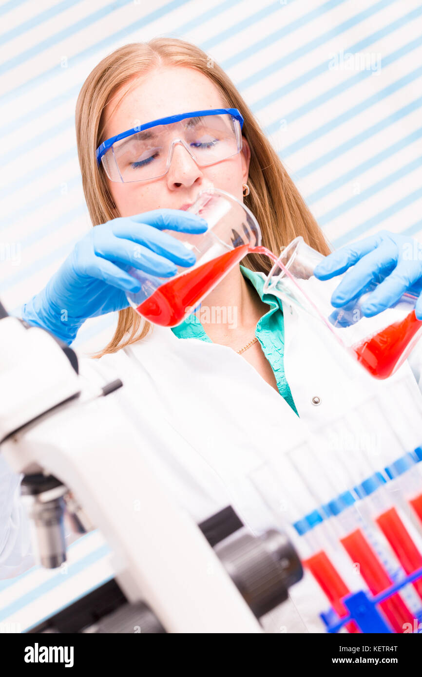 A female lab assistant doing scientific experiments in a scientific ...