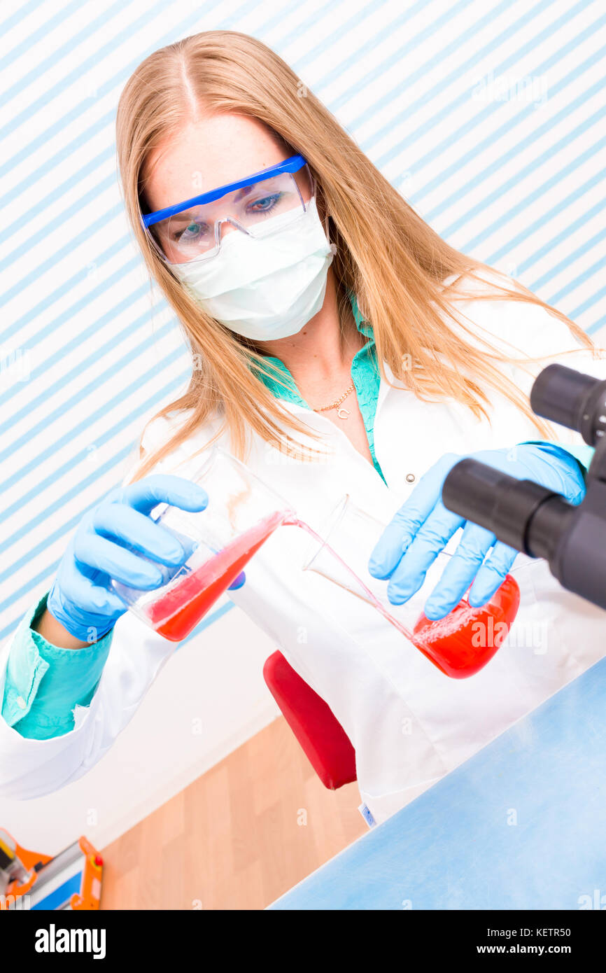 A female lab assistant doing scientific experiments in a scientific ...