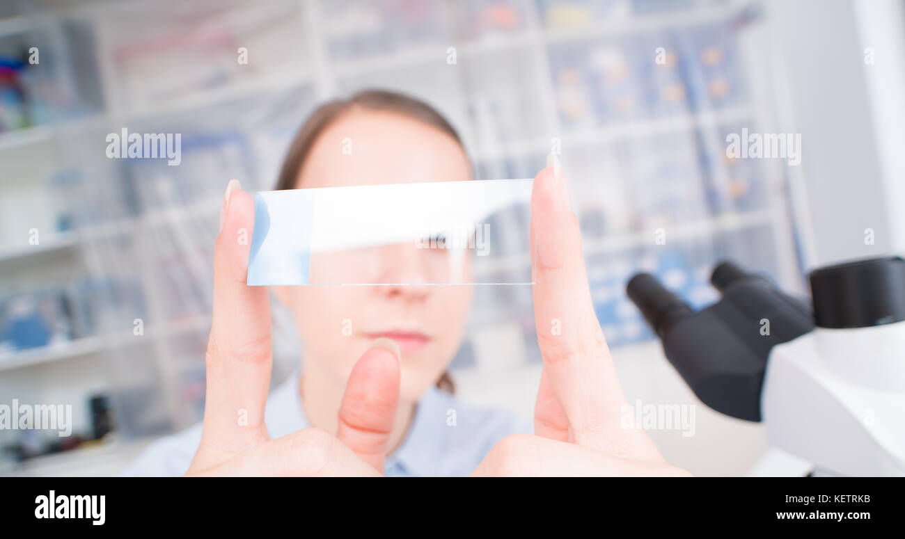 young woman scientific / female student researcher looking microscope ...