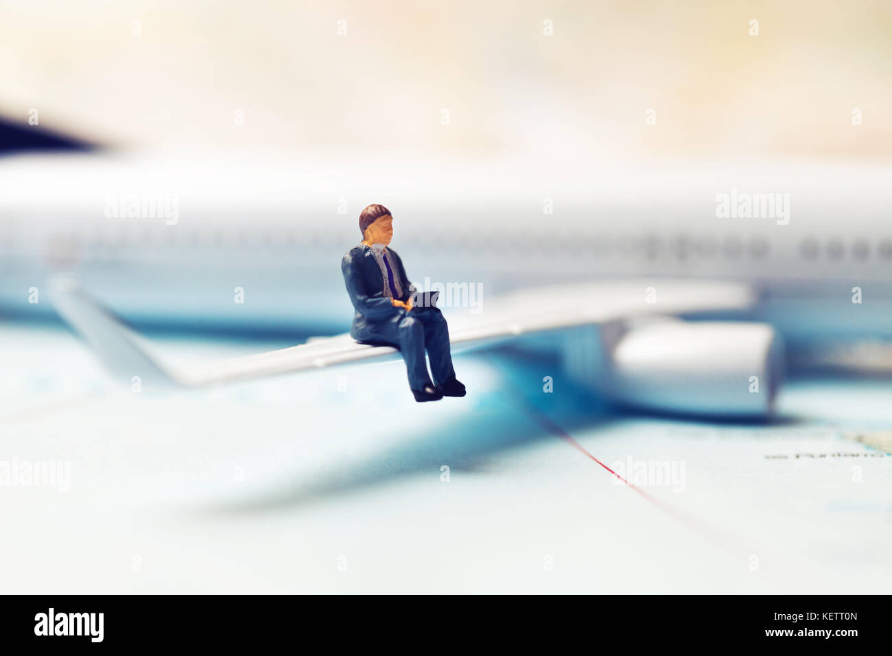 business travel concept - businessman sitting on a plane wing and ...