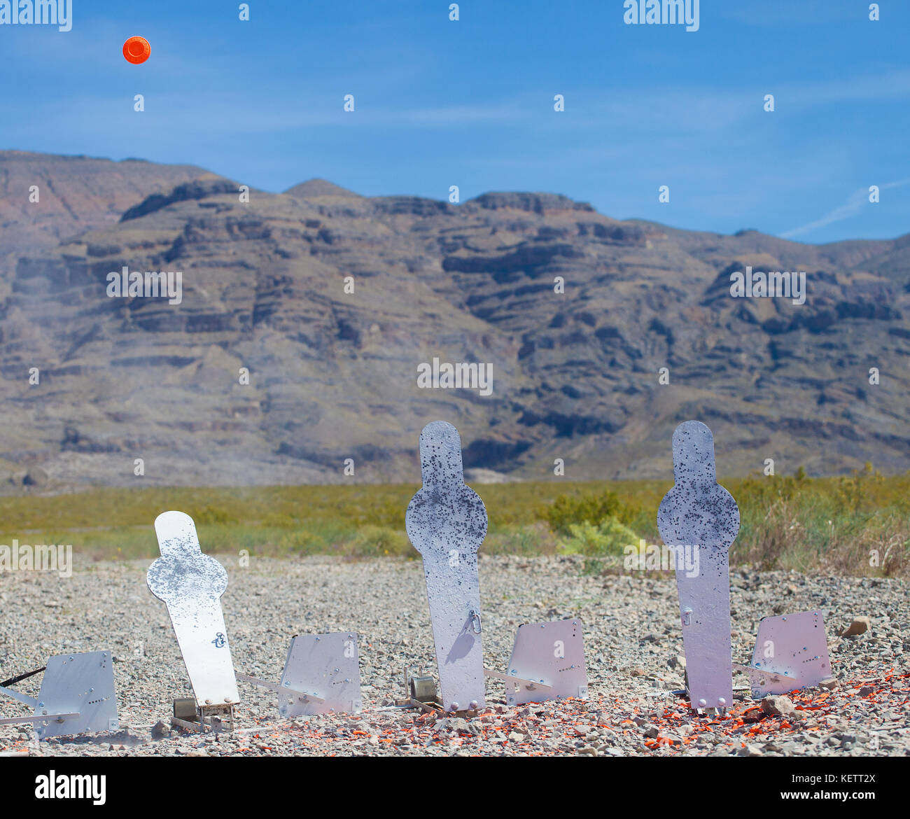 One steel shooting target going down as a clay flies Stock Photo - Alamy