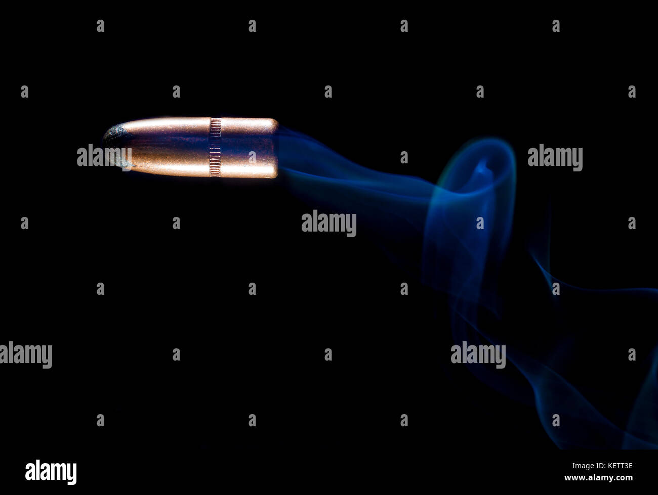 Copper plated bullet with smoke trailing on a black background Stock ...