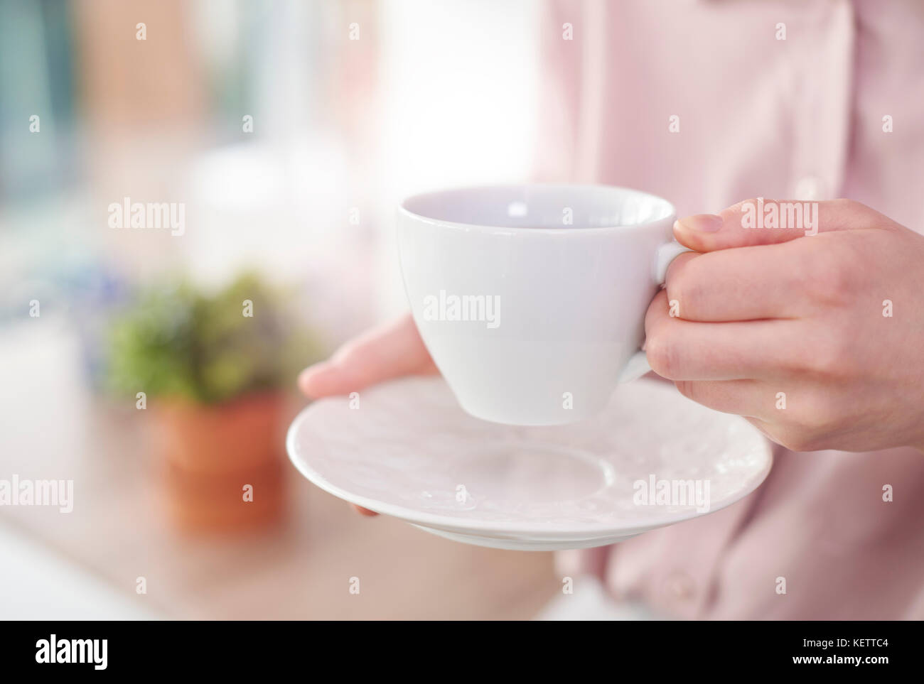 Human hand holding white cup with saucer Stock Photo - Alamy