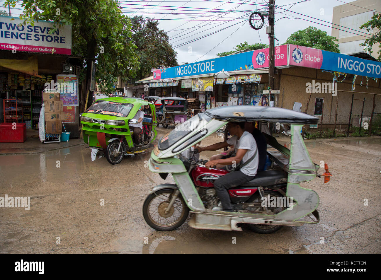 Motorized tricycles (auto rickshaw) in wet streets of El Nido, Palawan ...