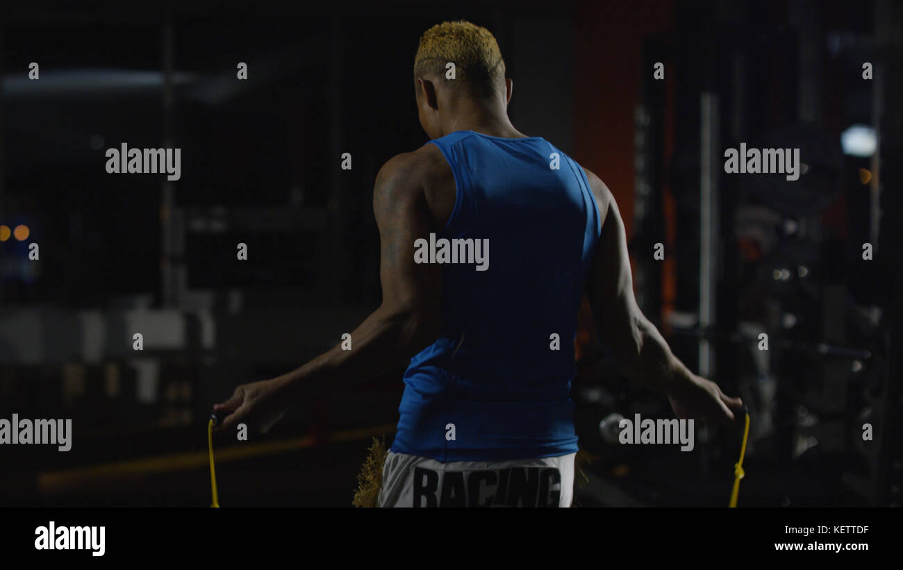 Full length portrait of a boxer jumping with skipping rope. Athletic ...