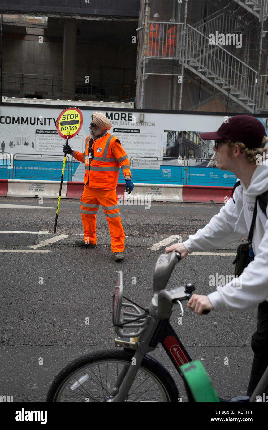 A Sikh wears his traditional turban as he stops traffic on Oxford ...