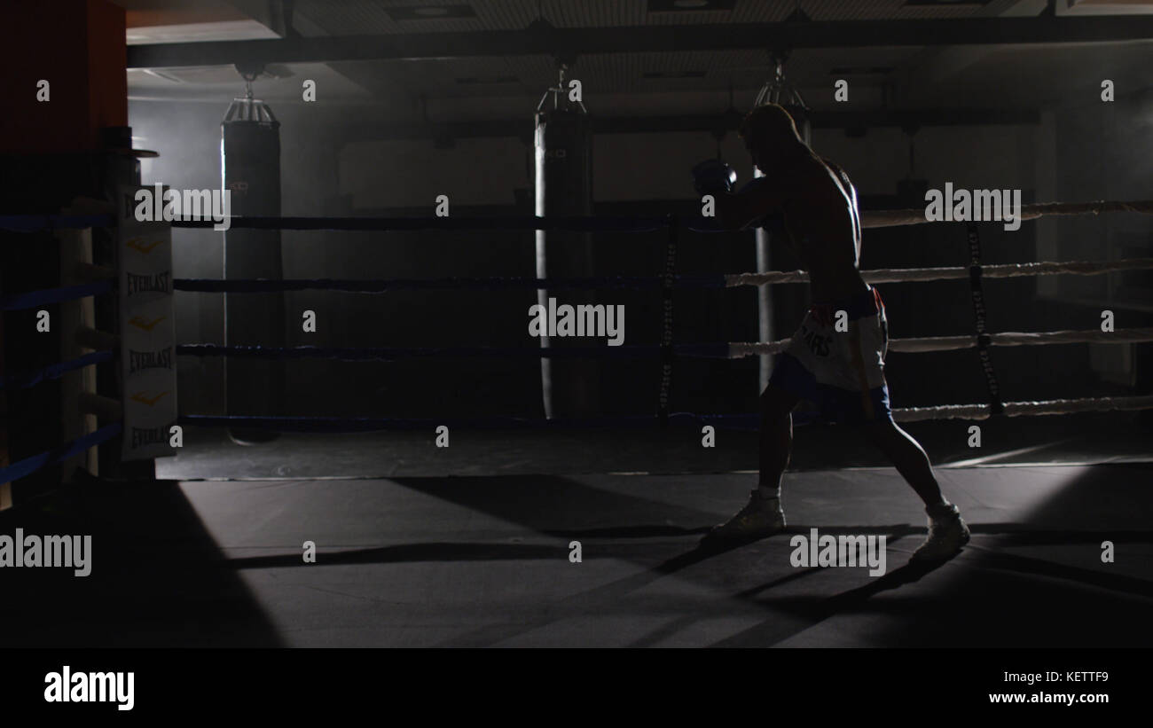Kickbox fighter shadow boxing in the ring. The athlete fights with his ...