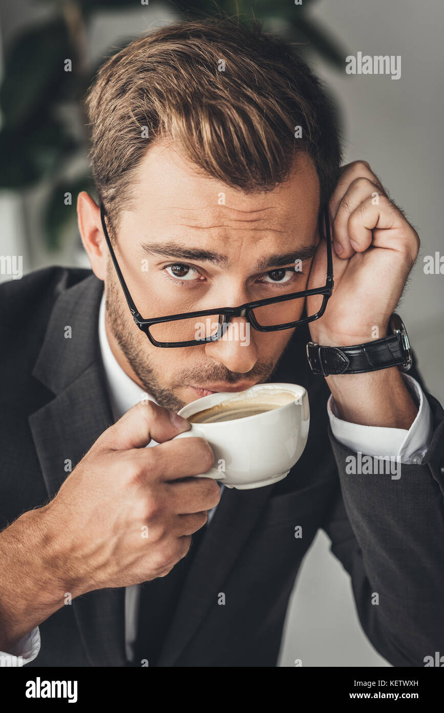 overworked businessman drinking coffee Stock Photo - Alamy