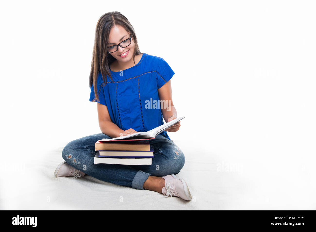 Beautiful student girl sitting and studying from books isolated on ...