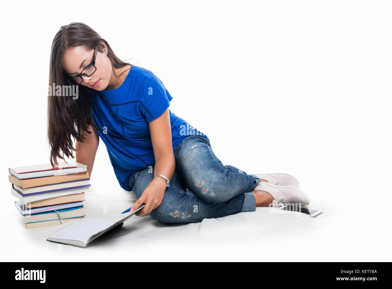Student sitting down looking in agenda with books around isolated on ...