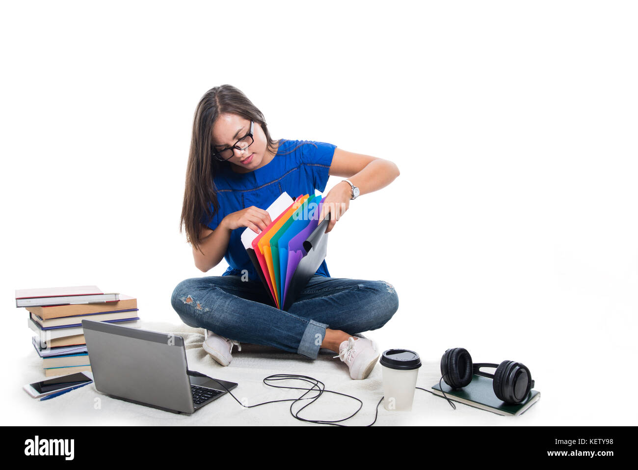 Pretty student girl sitting down searching throw files with books ...