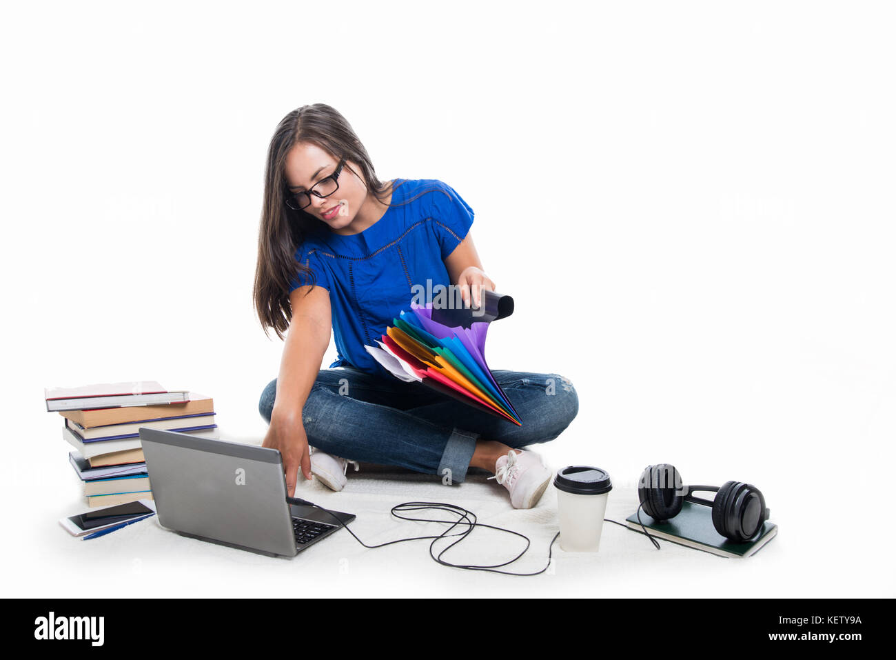 Beautiful student girl sitting down searching throw files with books ...