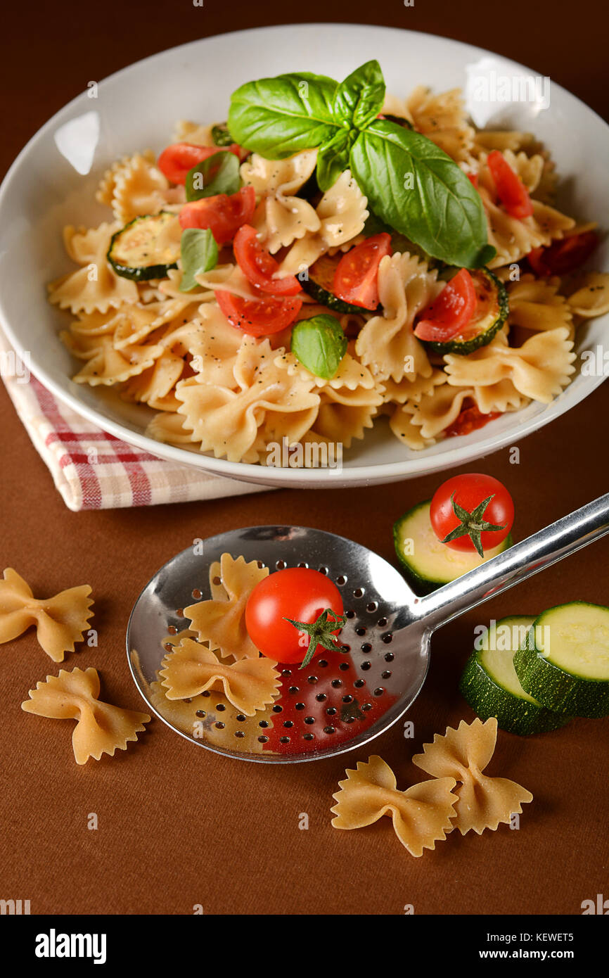 Butterfly pasta with tomato cherry and zucchini - closeup Stock Photo ...