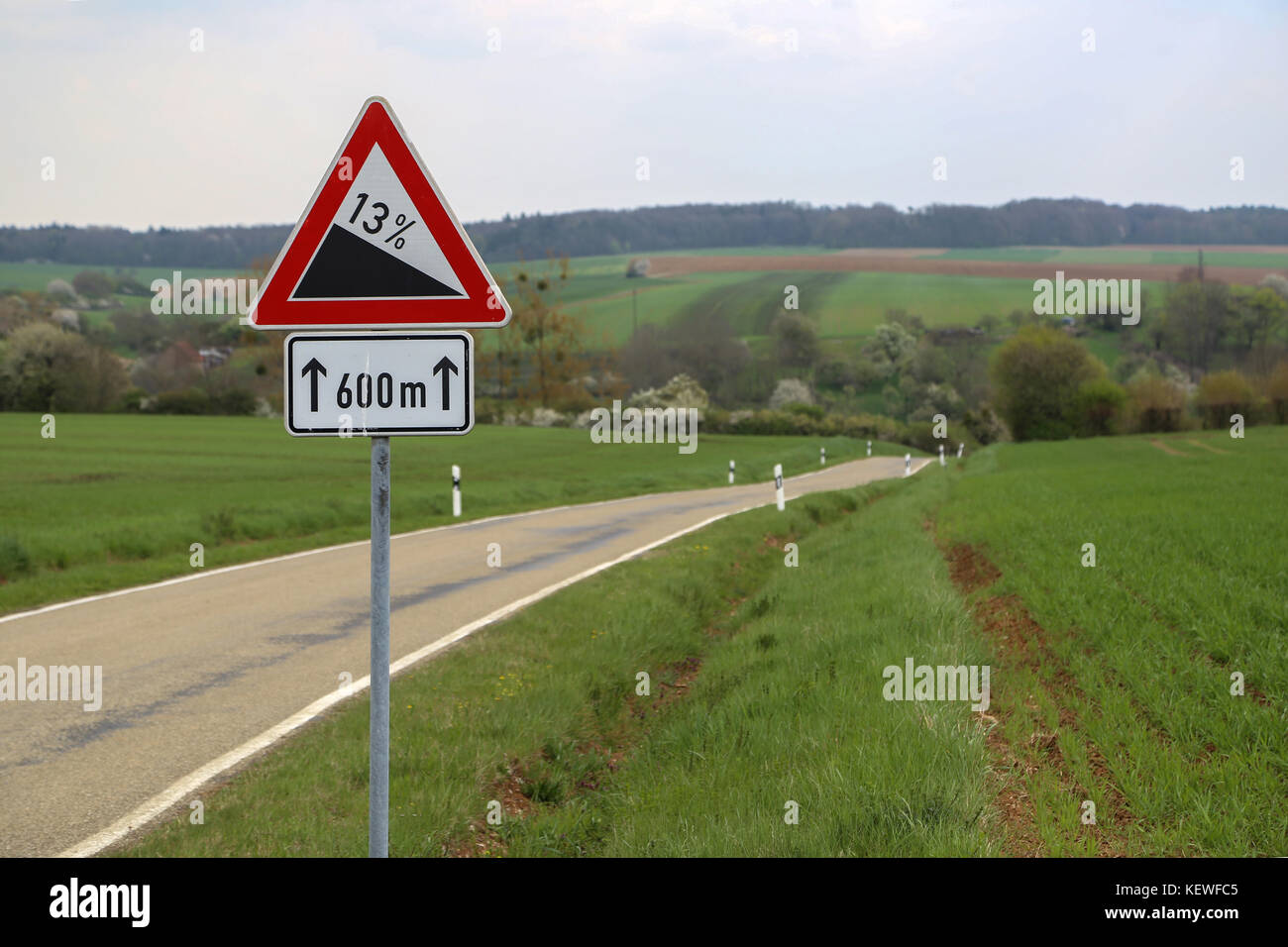 Road sign sloping road Stock Photo - Alamy