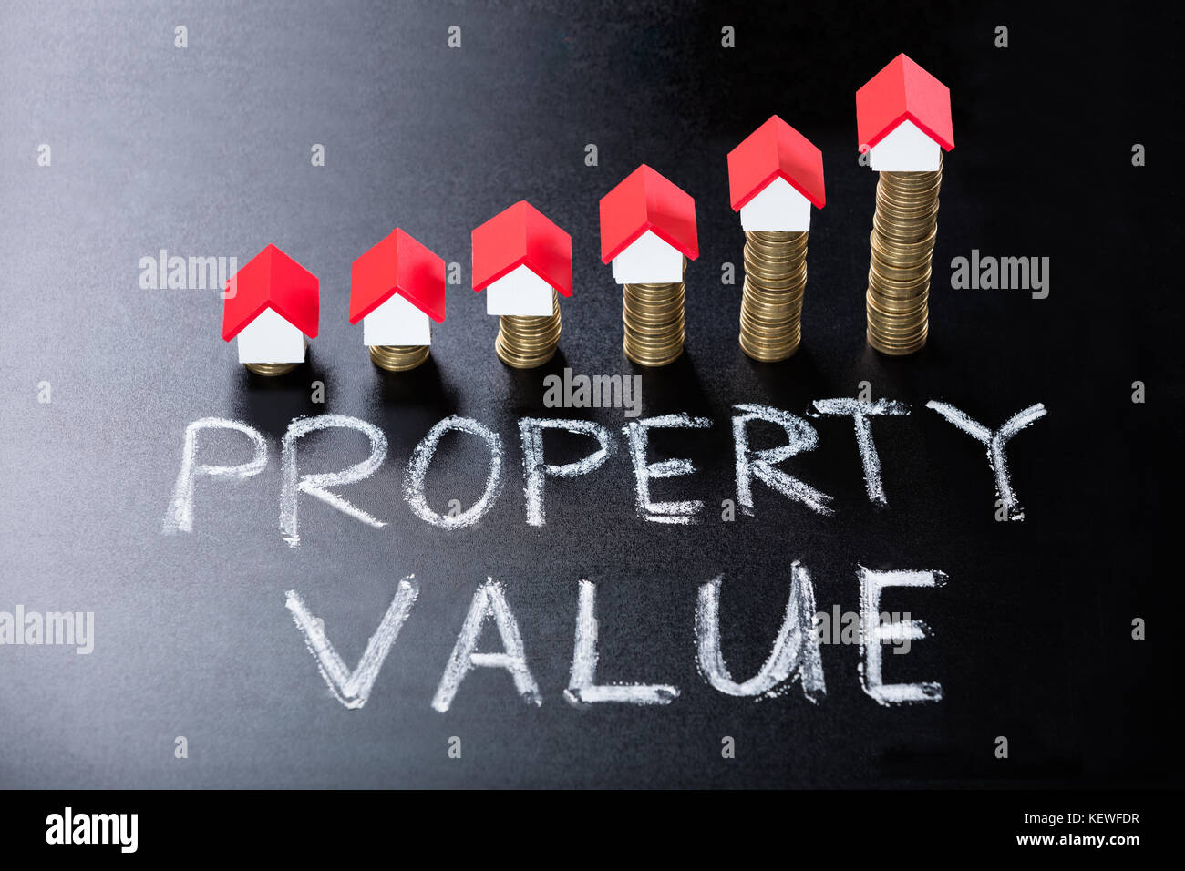 House Models On Stacked Coins Showing Property Value Concept On ...