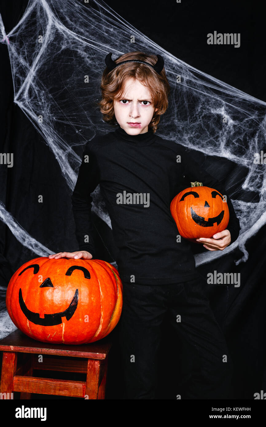 A young boy in halloween costume with pumpkins having fun Stock Photo ...