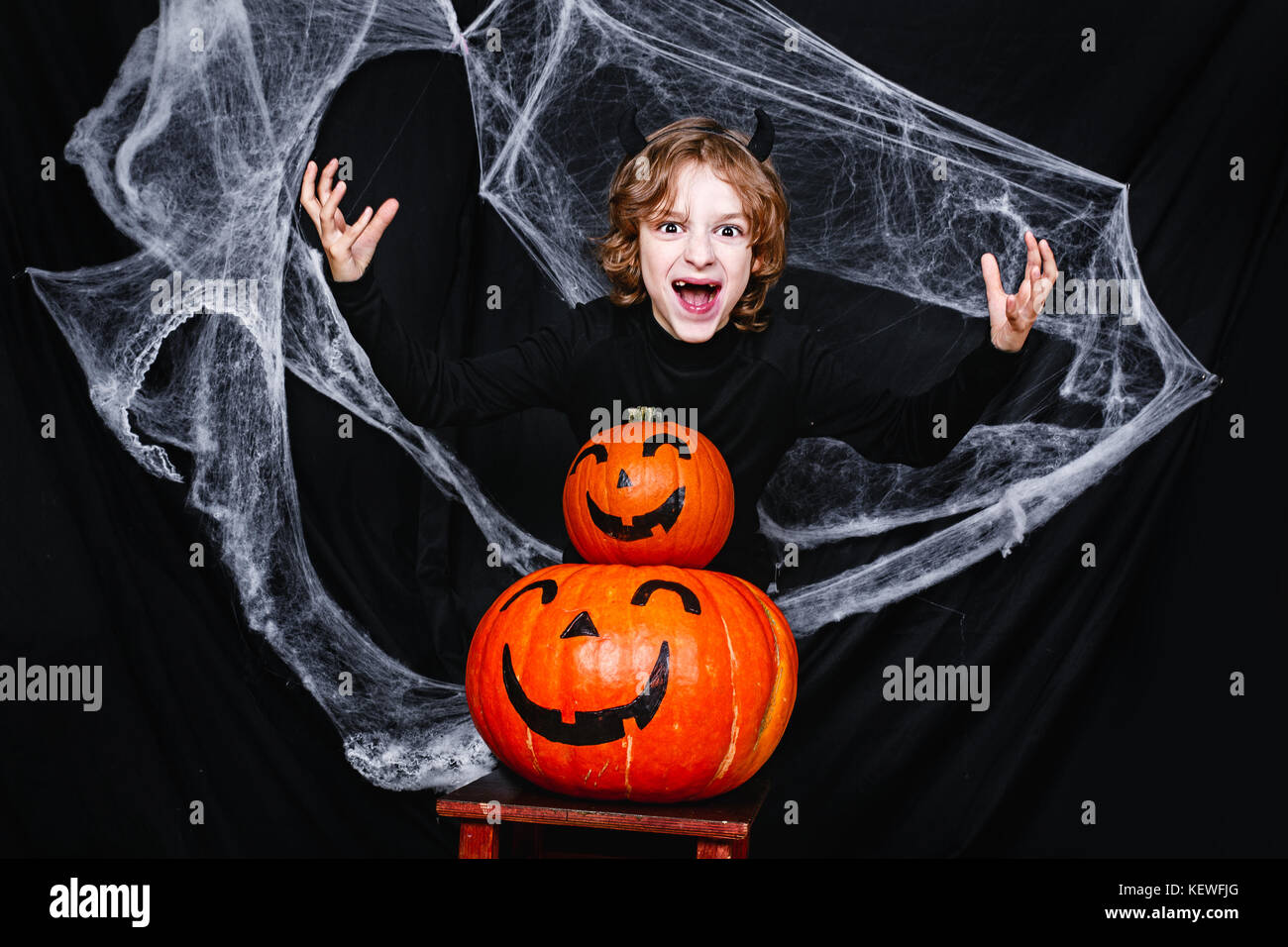 A young boy in halloween costume with pumpkins having fun Stock Photo ...