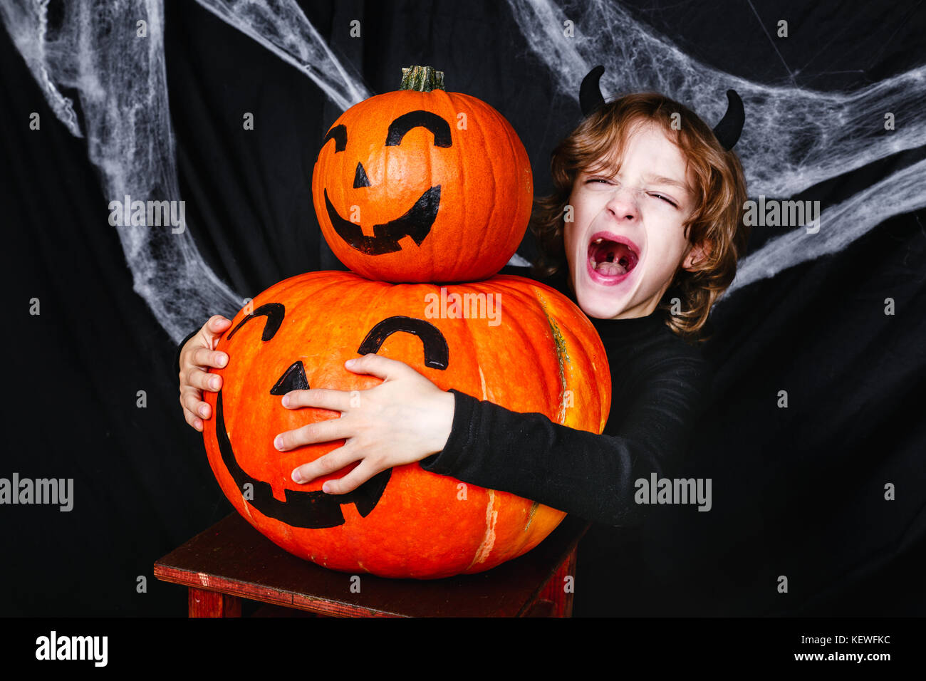 A young boy in halloween costume with pumpkins having fun Stock Photo ...