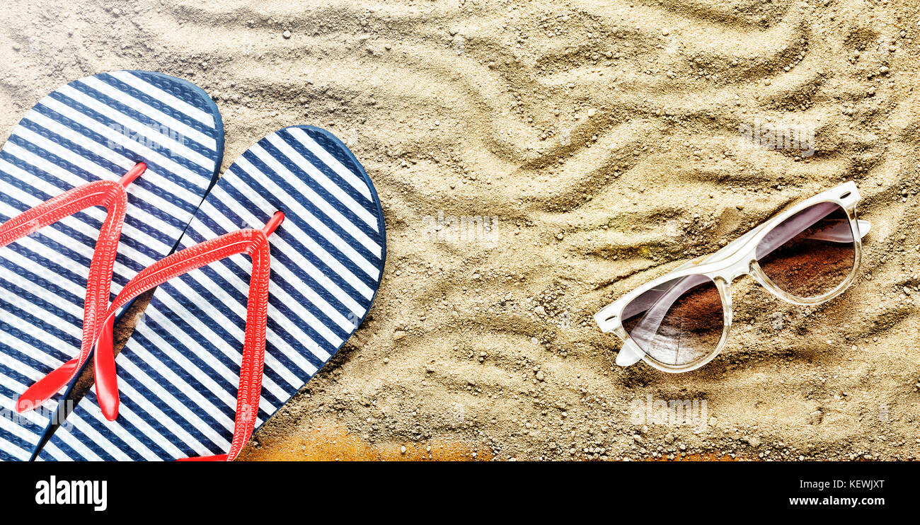 Beach background. Beach slippers and sunglasses on the seashore, golden ...