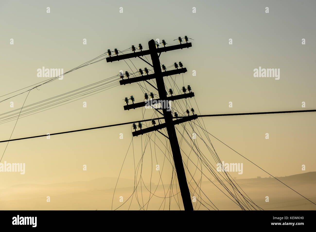 Old wooden pillar with power line in sunrise. Wooden pylon with wires ...