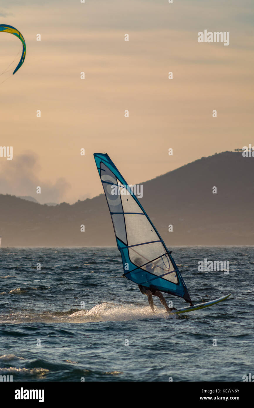 Sunset over the sea or ocean and extreme freestyle sport windsurfing ...