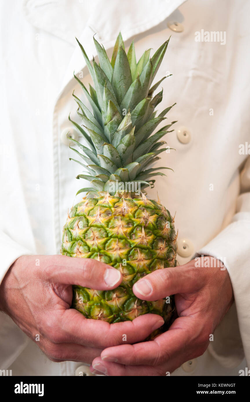 A man holds fruit, a fresh pineapple Stock Photo - Alamy