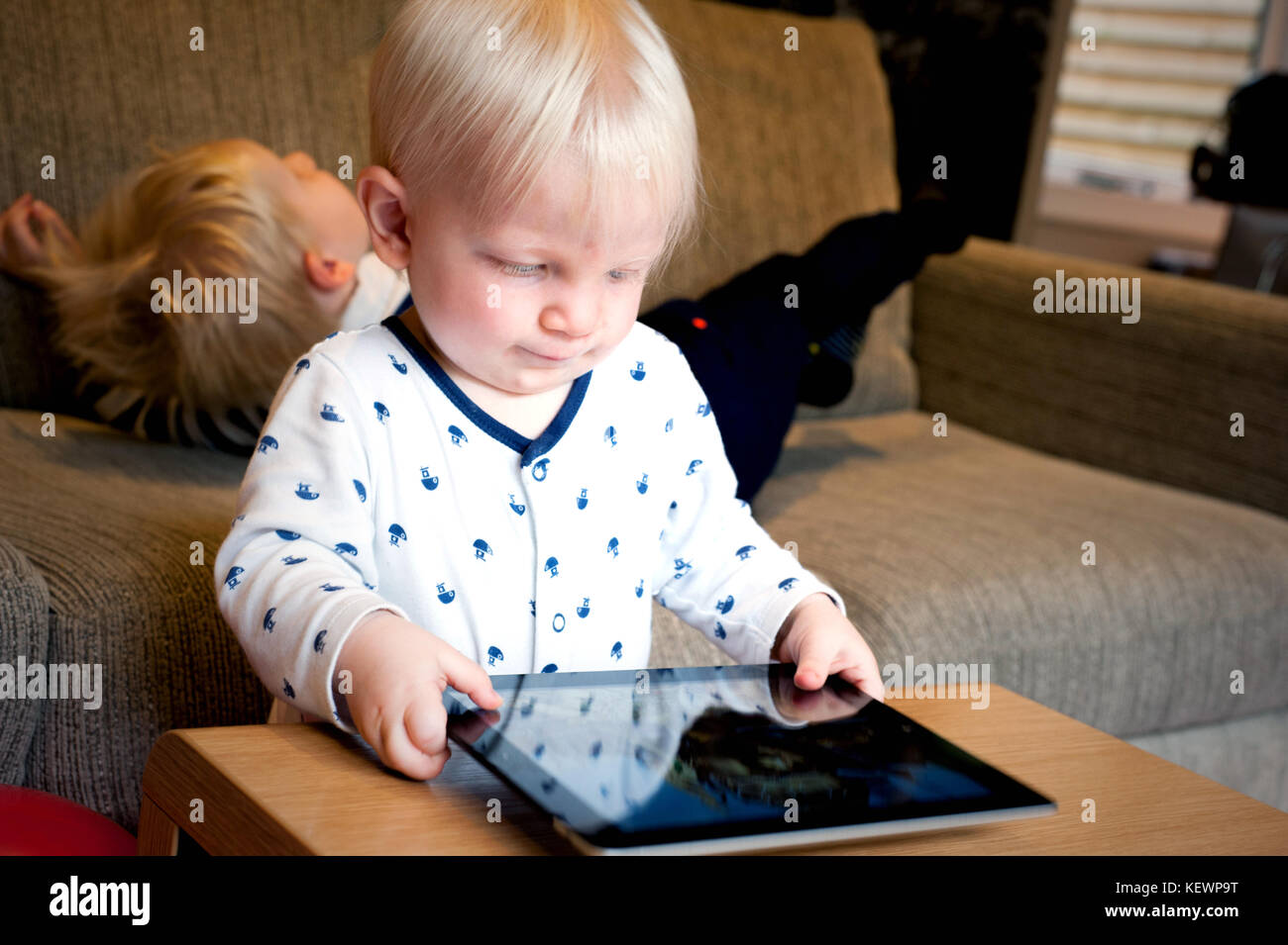 Baby boy looking at iPad tablet Stock Photo - Alamy