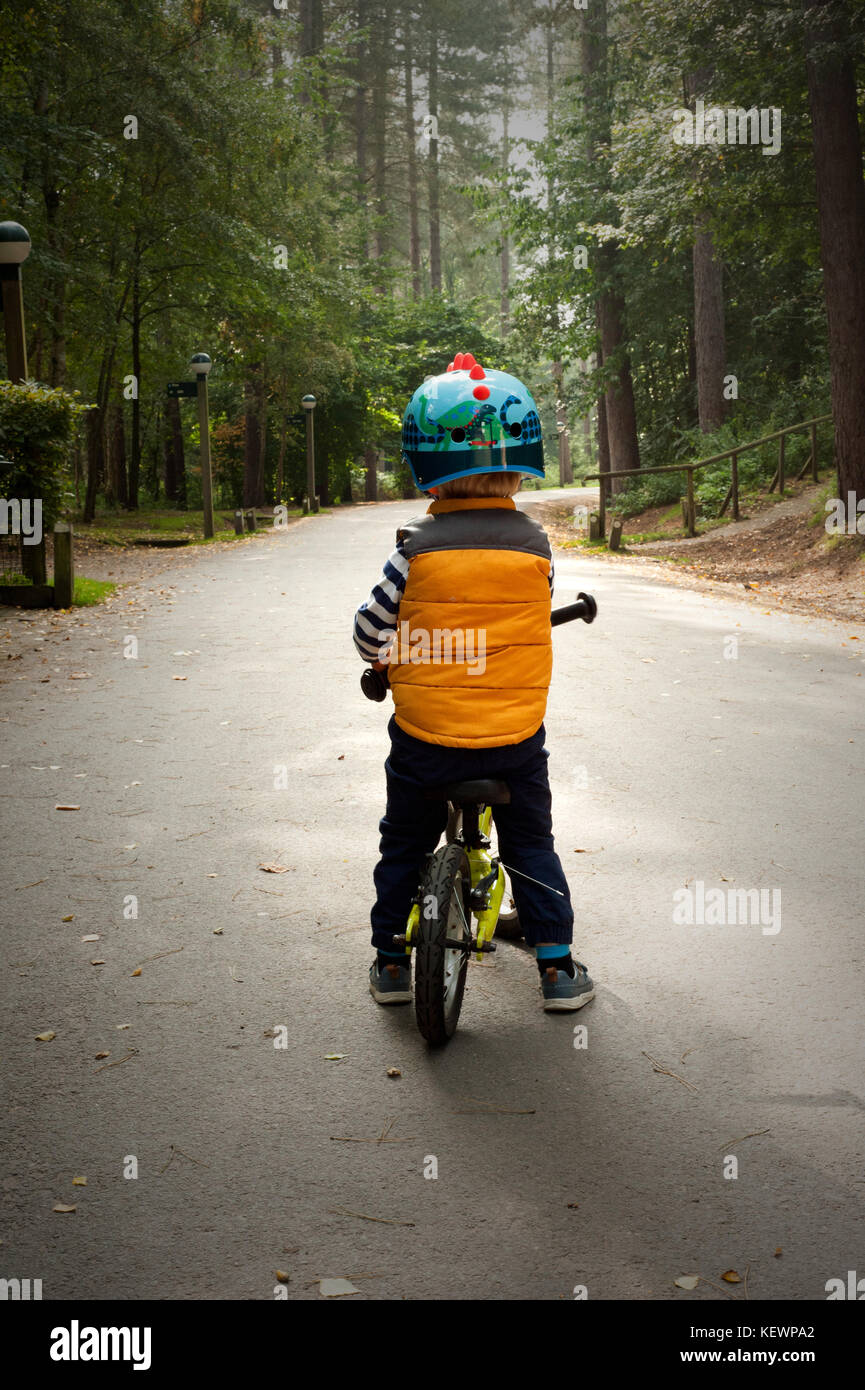 Little boy riding a bike down a forest path Stock Photo - Alamy