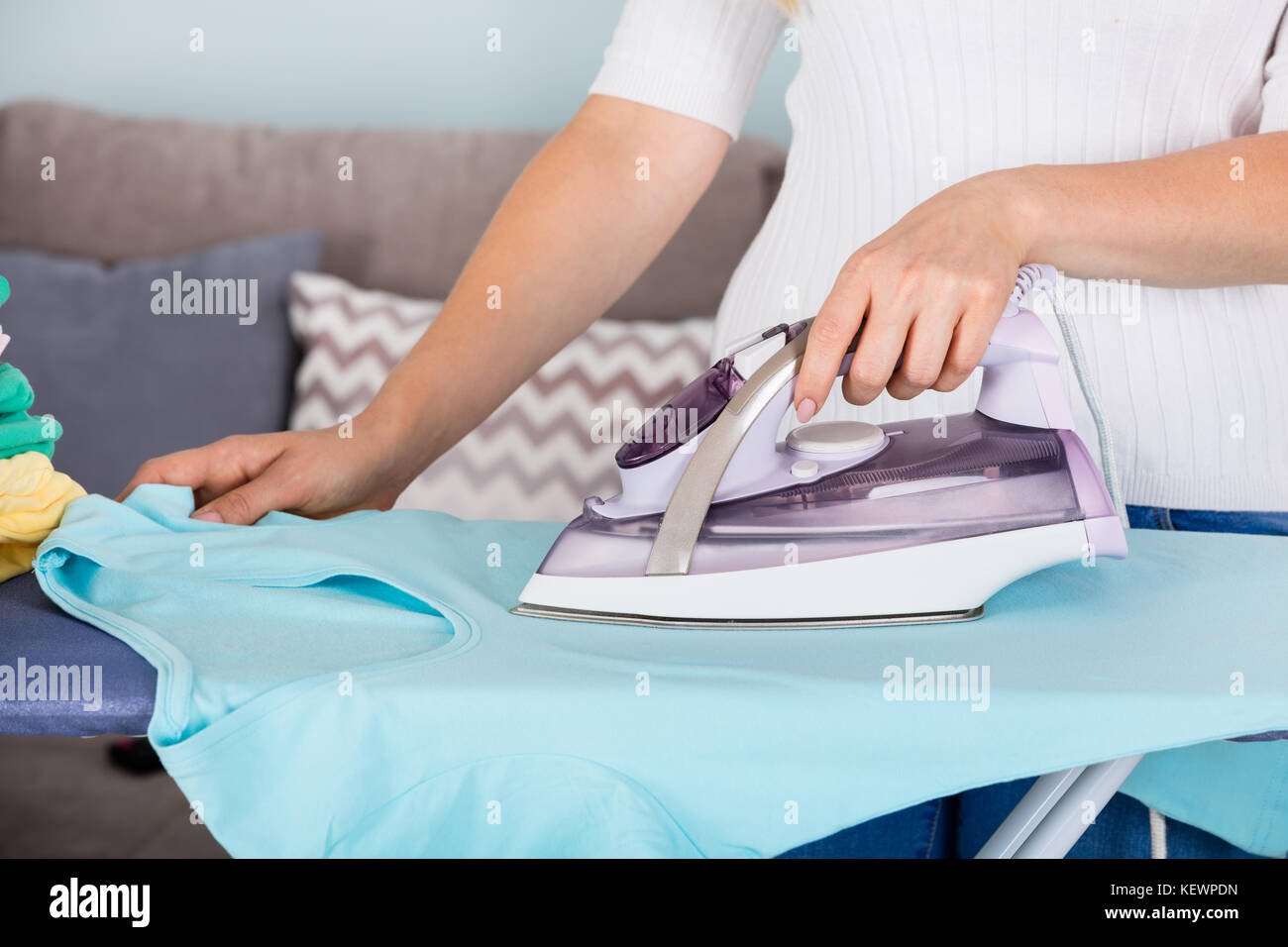 Close-up Of Maid Hand Ironing Clothes On Ironing Board At Home Stock ...