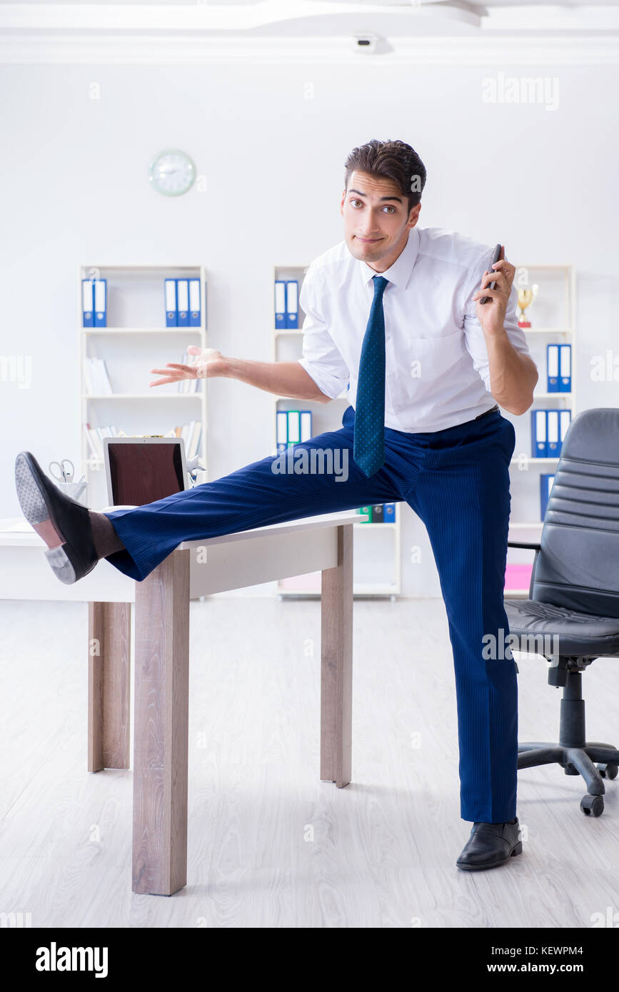 Young businessman doing sports stretching at workplace Stock Photo - Alamy