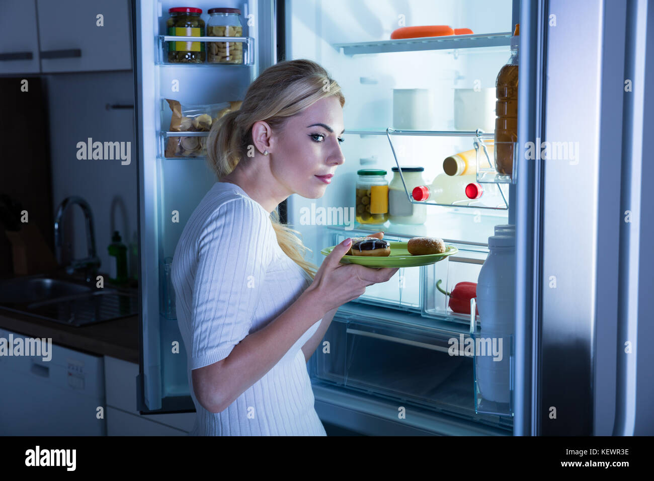 Suspicious Woman Taking Sweet Food Secretly From Fridge In The Kitchen ...