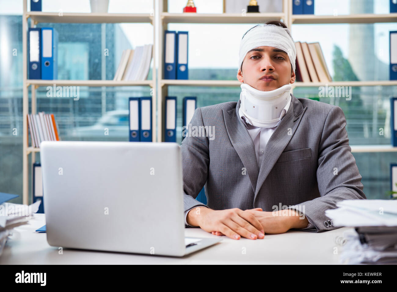 Injured businessman working in the office Stock Photo - Alamy