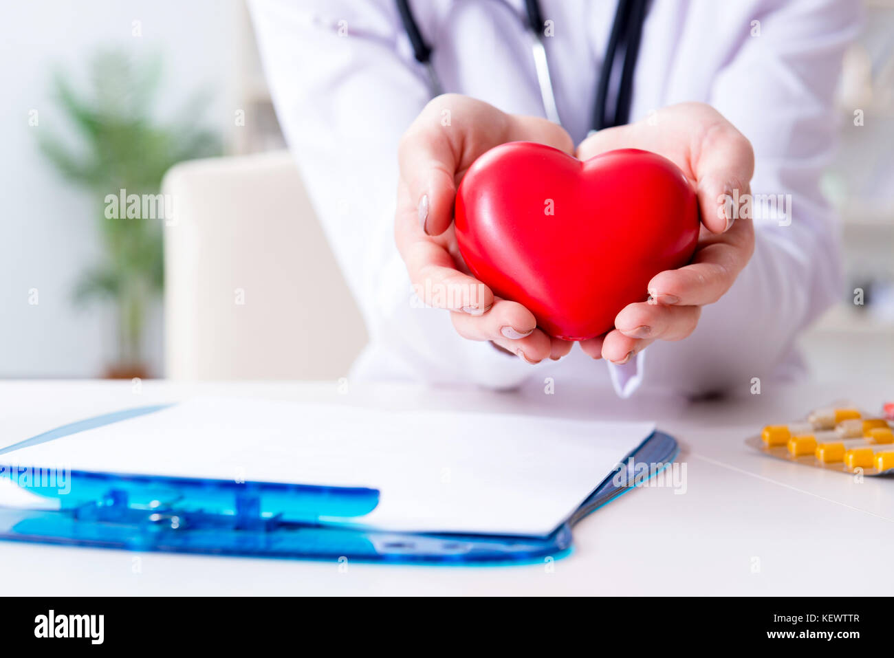 Doctor cardiologist with red heart in the hospital Stock Photo - Alamy