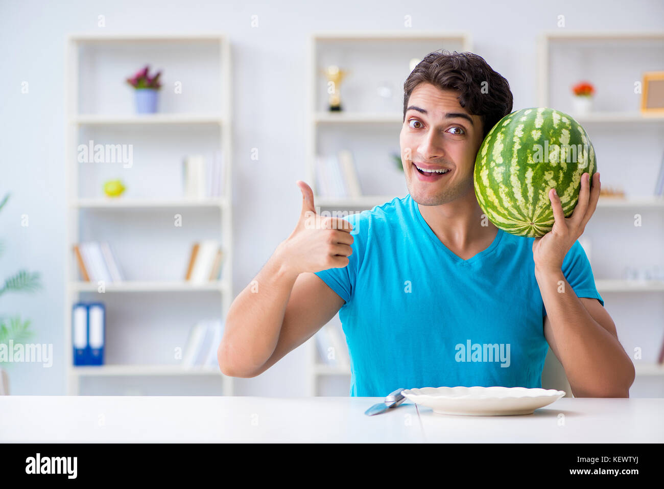 Man eating watermelon at home Stock Photo - Alamy