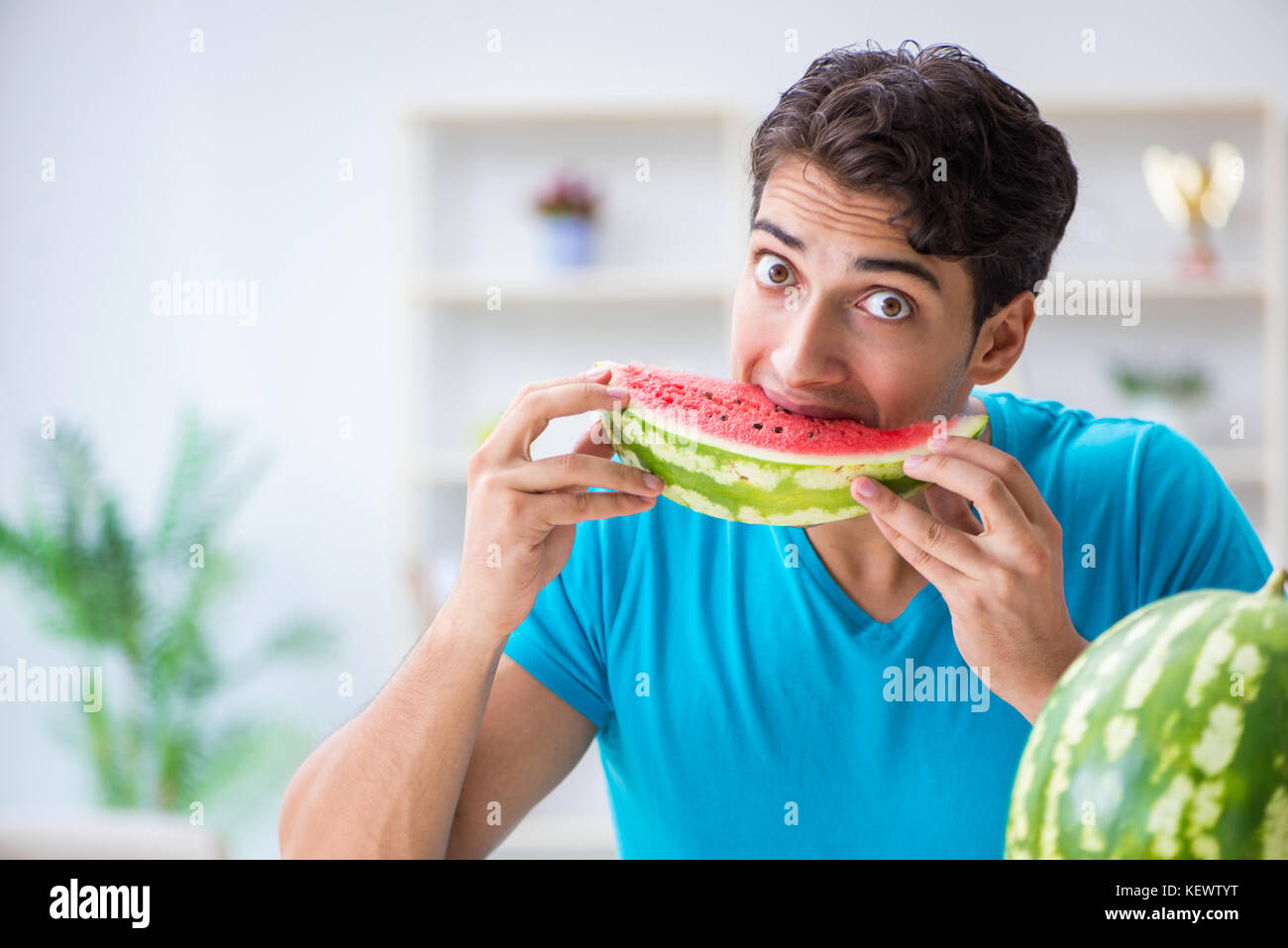 Man eating watermelon at home Stock Photo - Alamy