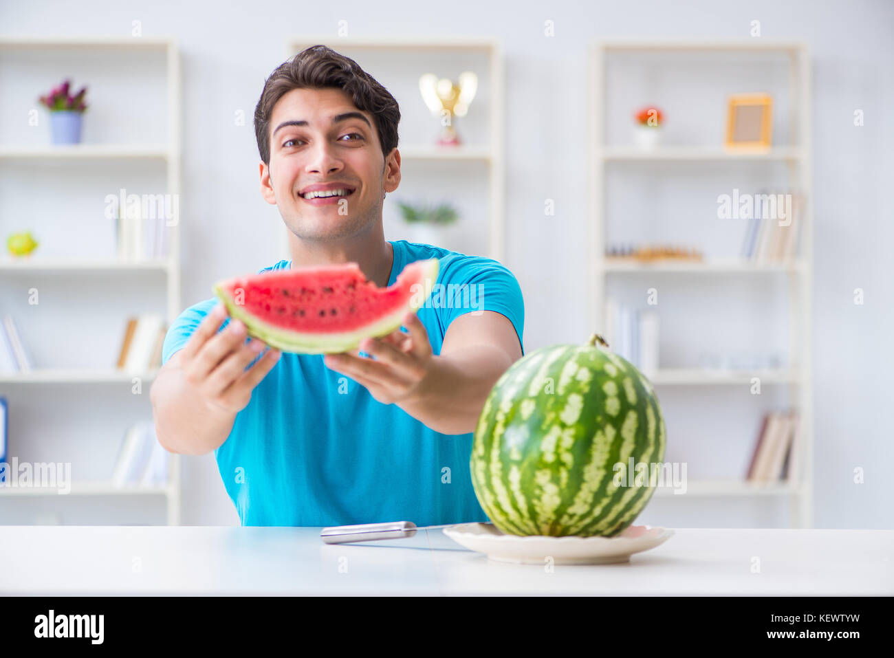 Man eating watermelon at home Stock Photo - Alamy
