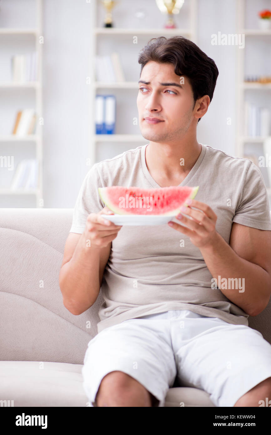Man eating watermelon at home Stock Photo - Alamy