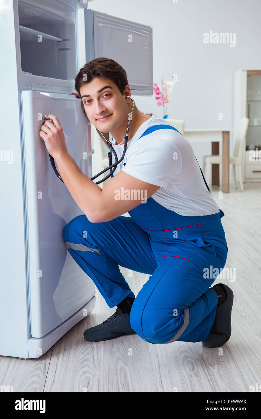 Repairman contractor repairing fridge in DIY concept Stock Photo - Alamy