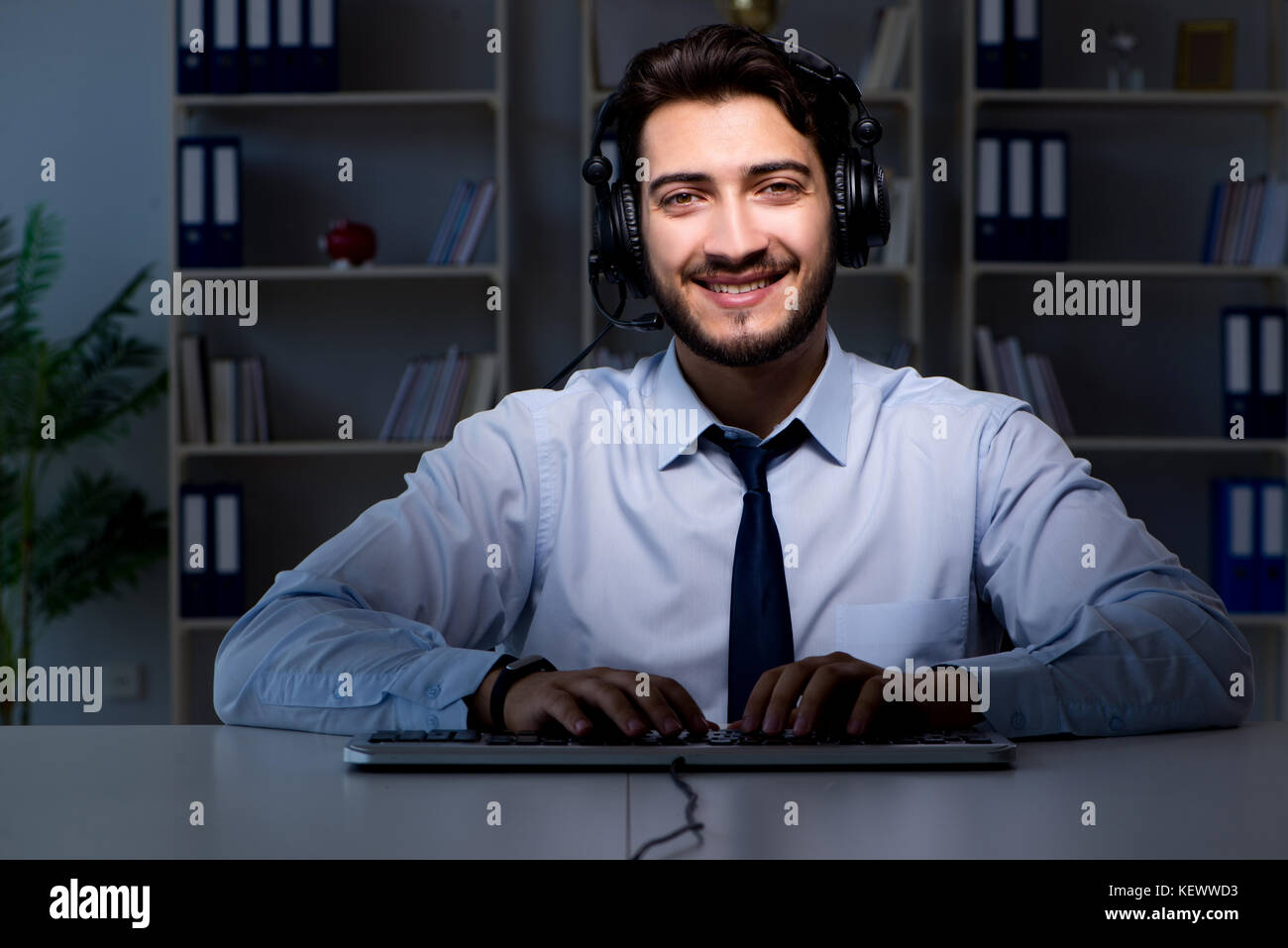Young man in call center concept working late overtime in office Stock ...