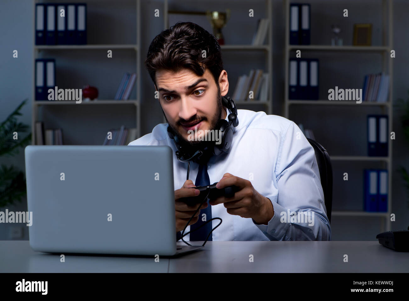 Businessman gamer staying late to play games Stock Photo - Alamy