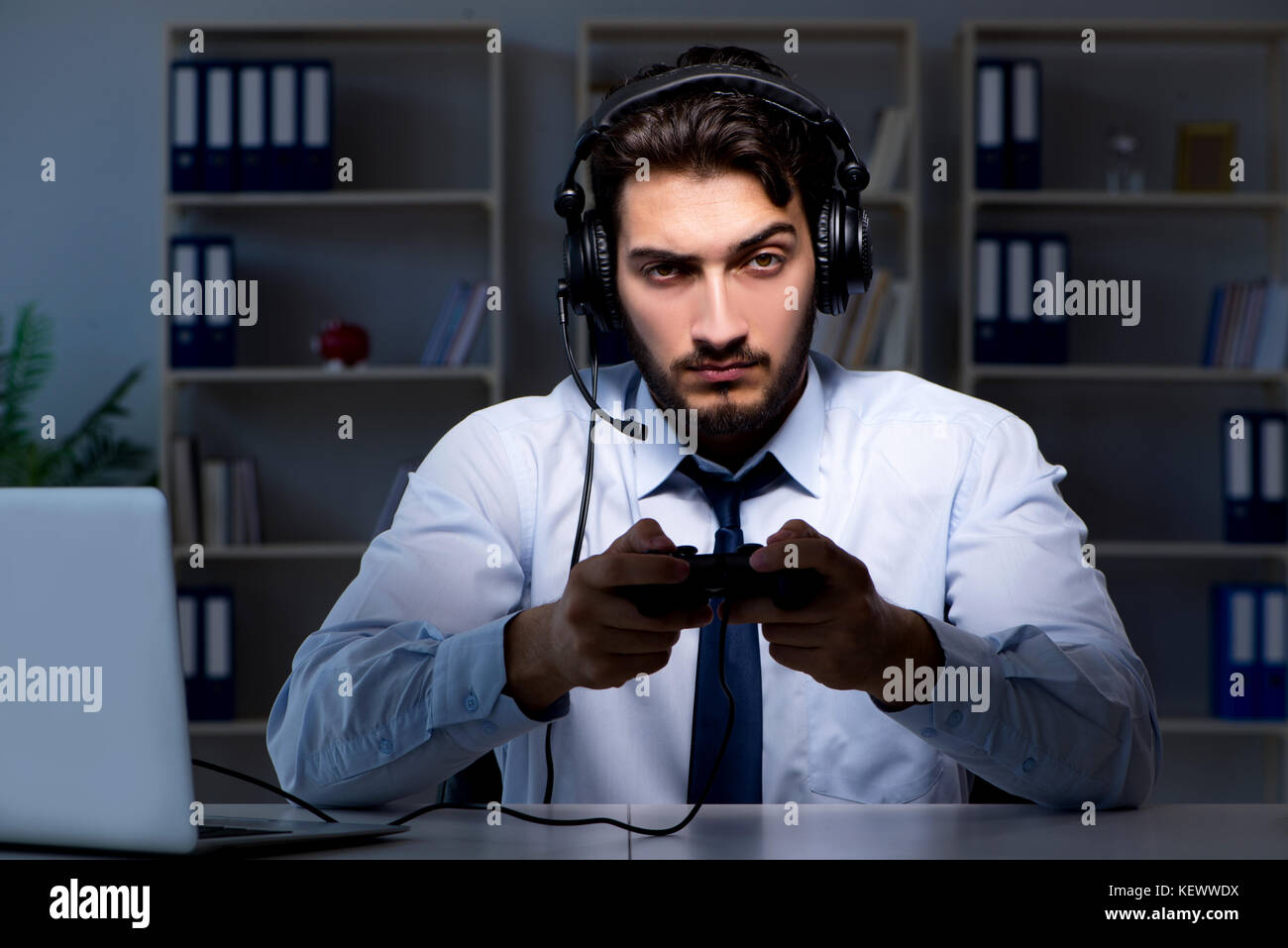 Businessman gamer staying late to play games Stock Photo - Alamy
