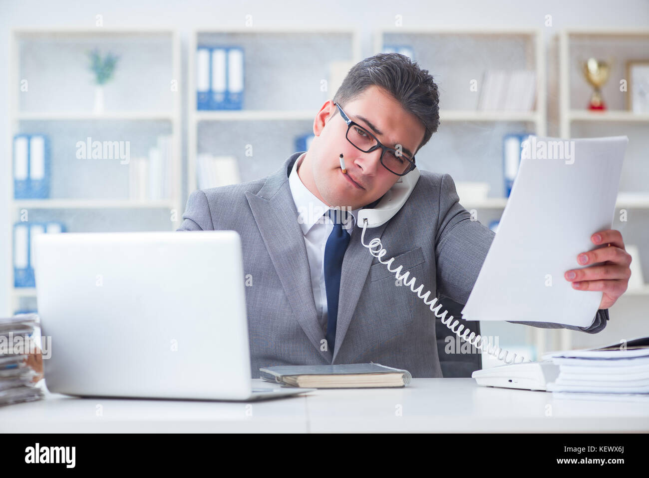 Businessman smoking in office at work Stock Photo - Alamy
