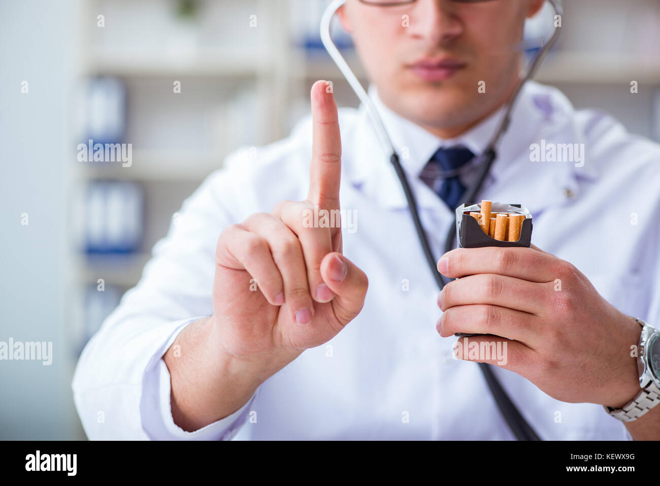 Male doctor in anti-smoking conceptwithcigarette pack Stock Photo - Alamy