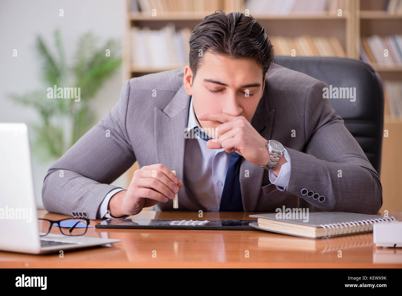 Drug addict businessman in the office Stock Photo - Alamy