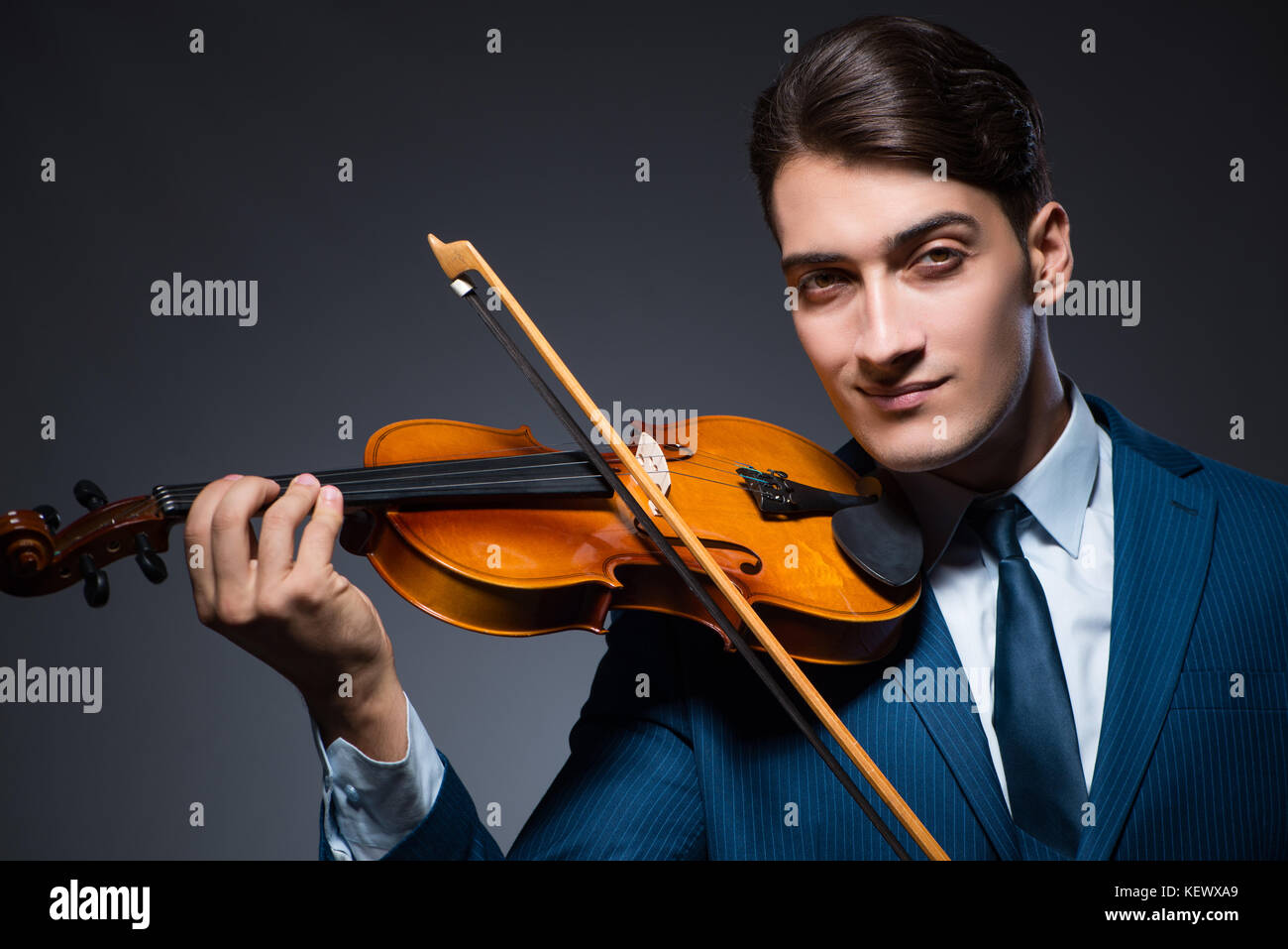Young man playing violin in dark room Stock Photo - Alamy
