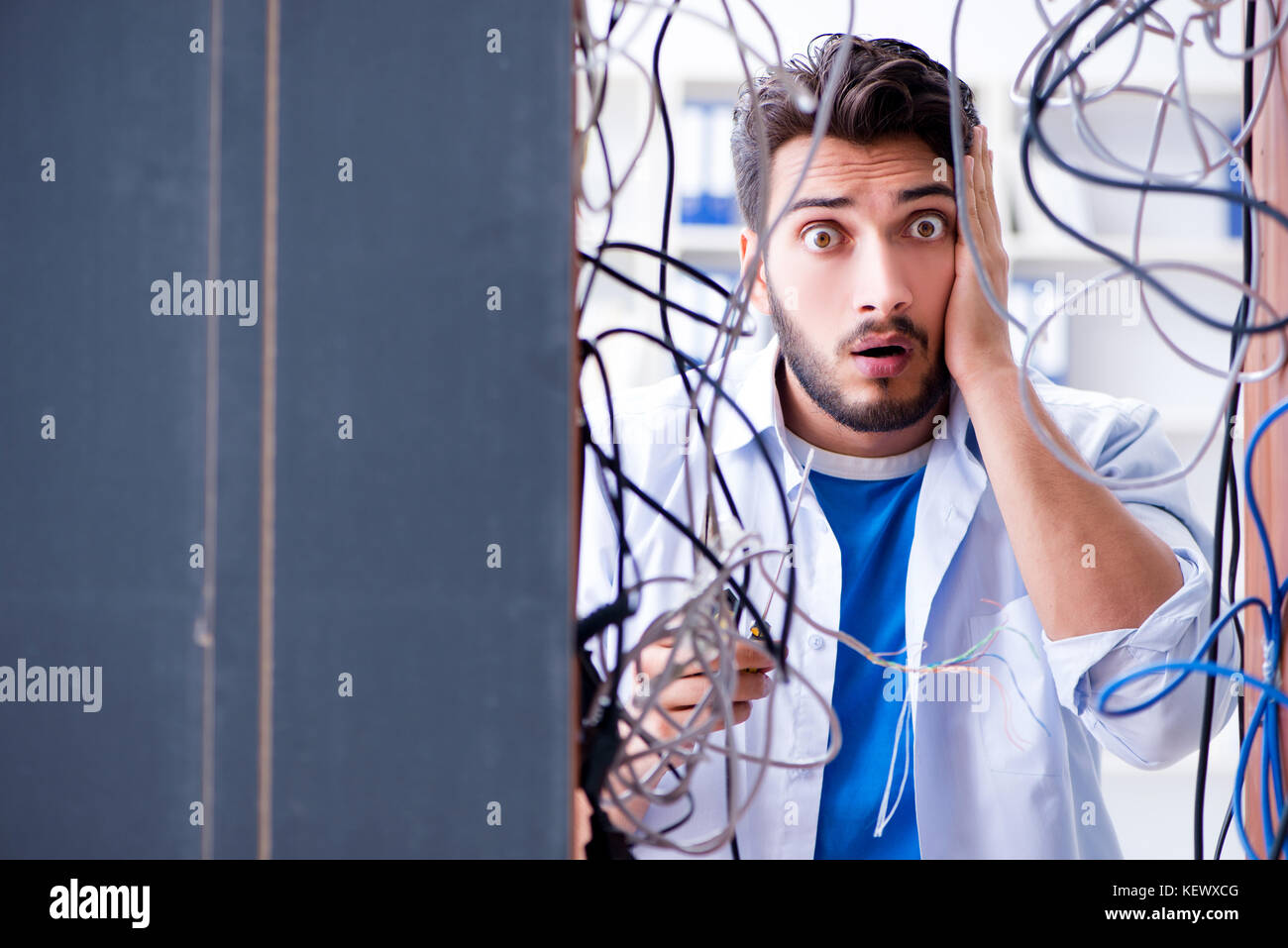 Electrician trying to untangle wires in repair concept Stock Photo - Alamy
