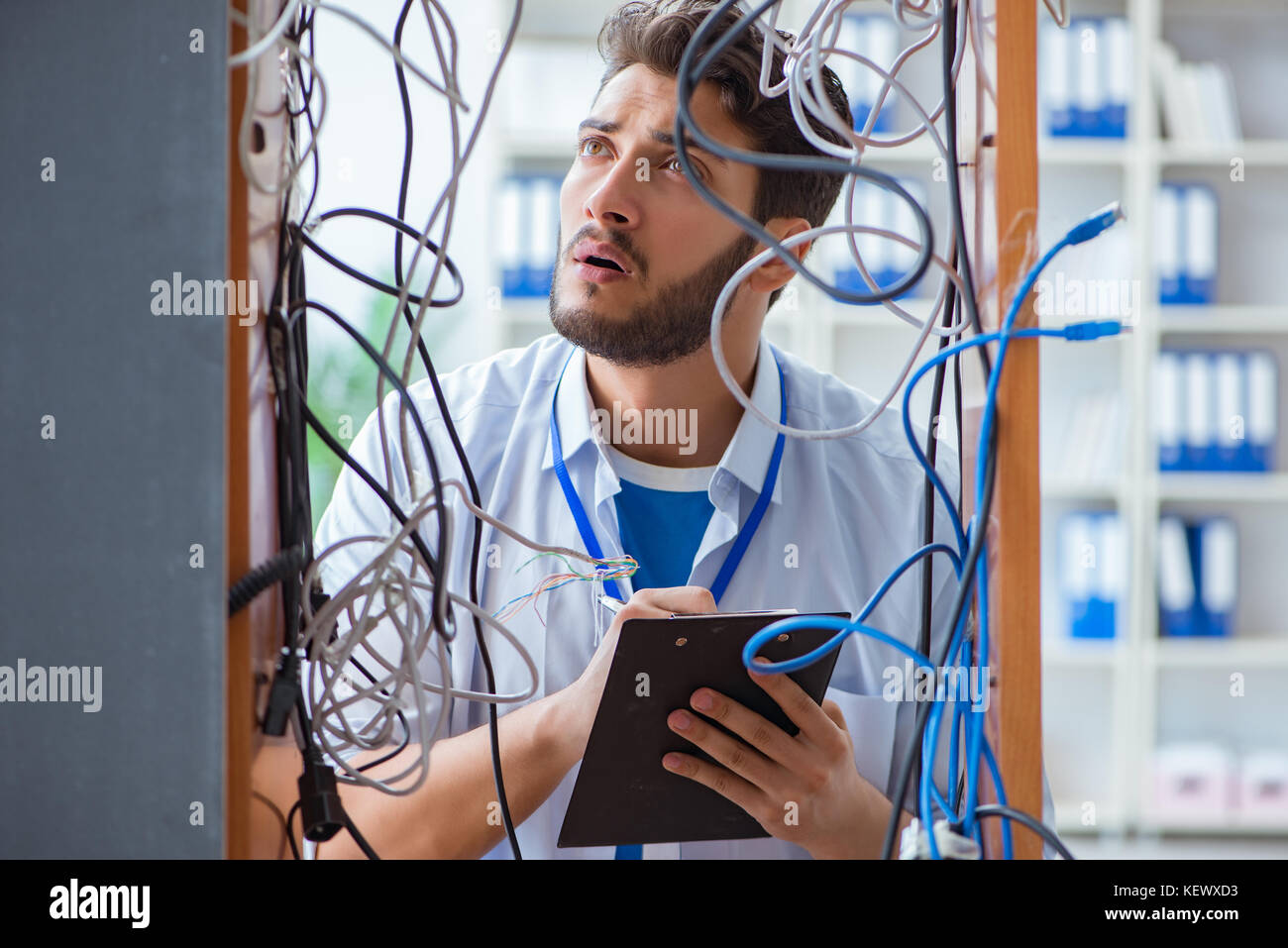 Electrician trying to untangle wires in repair concept Stock Photo - Alamy
