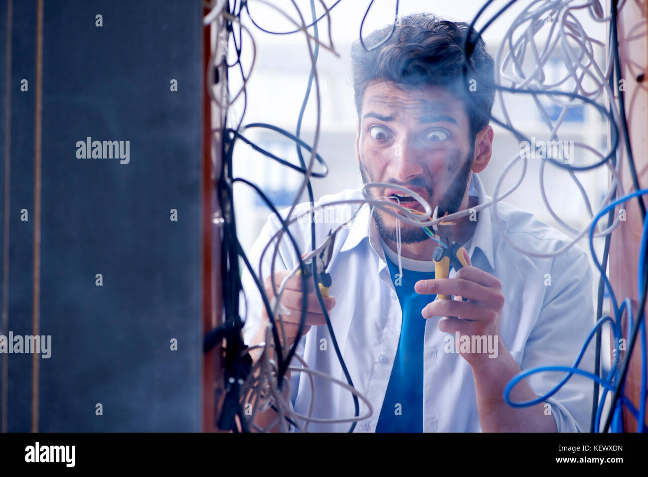 Electrician trying to untangle wires in repair concept Stock Photo - Alamy