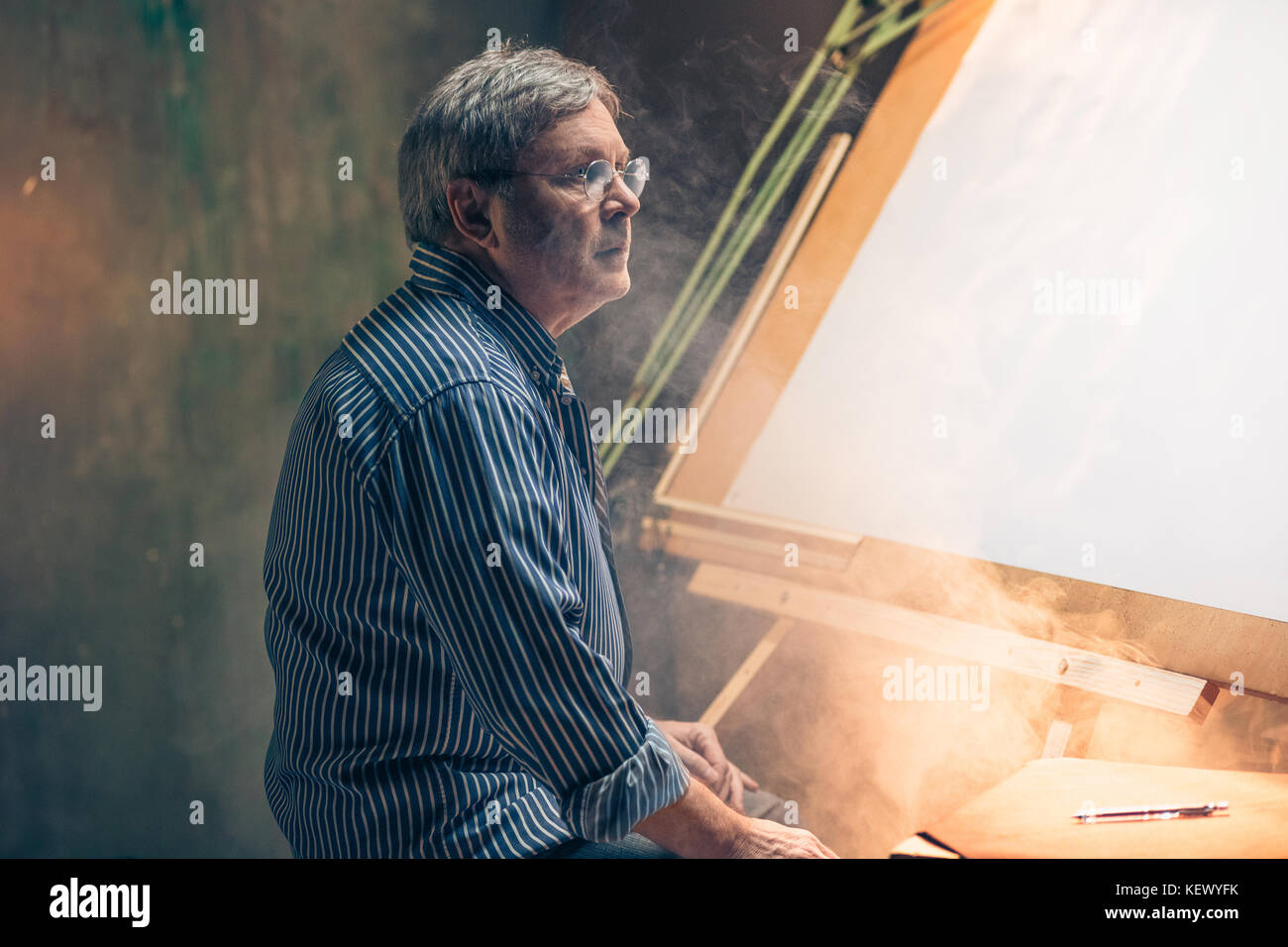 The mature creative engineer working with project on drawing board ...